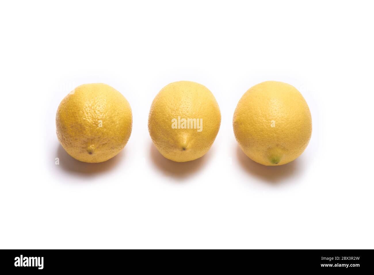 Three lemons on a white background in the center Stock Photo - Alamy