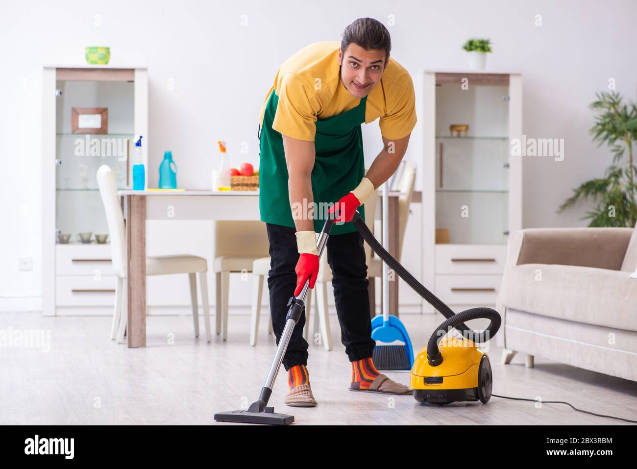Young contractor cleaning the house Stock Photo - Alamy