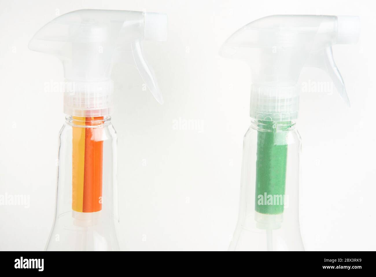 A close-up of the top portion of two transparent nozzle liquid spray ...