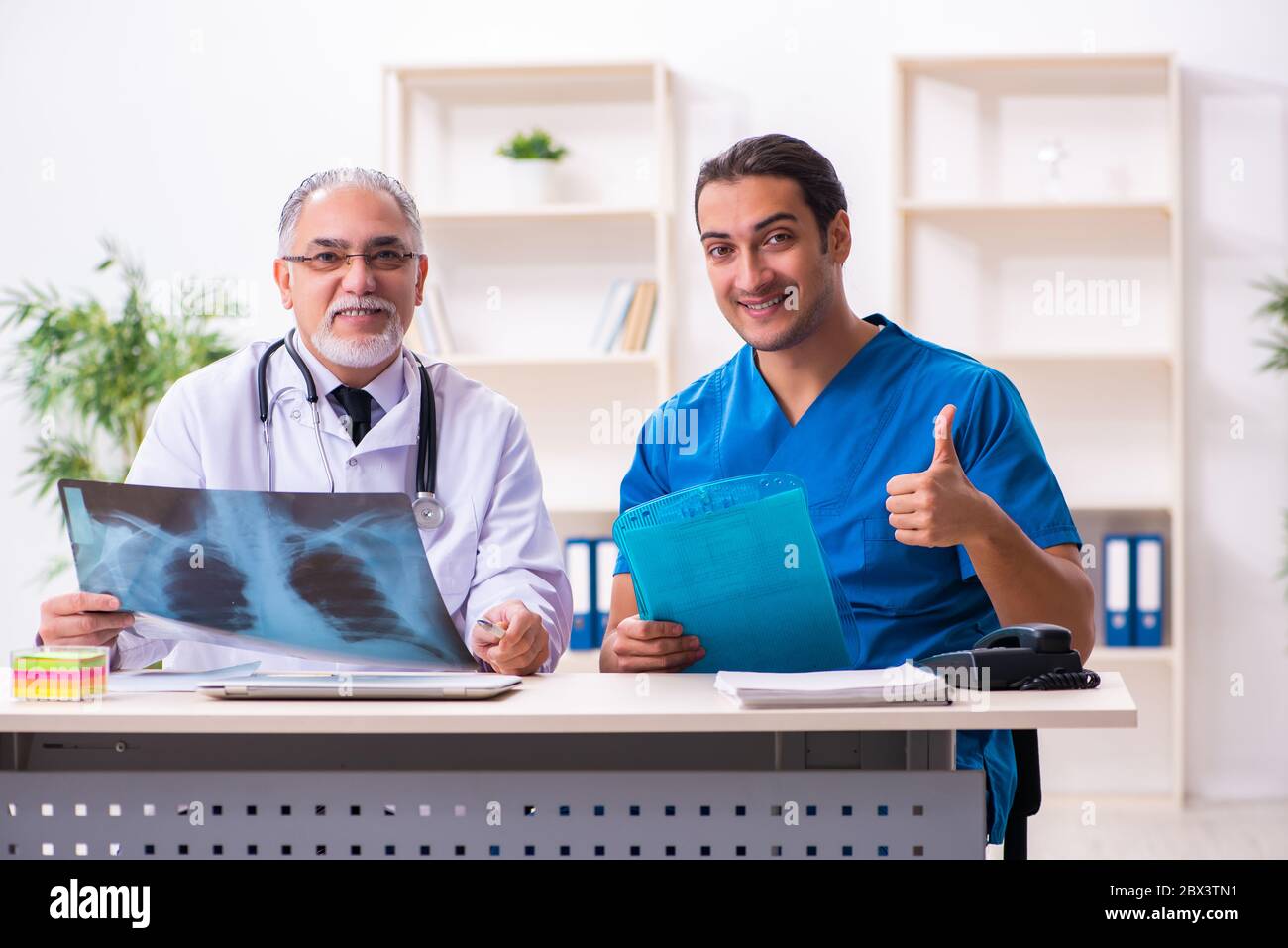 Two male doctors working in the modern clinic Stock Photo - Alamy