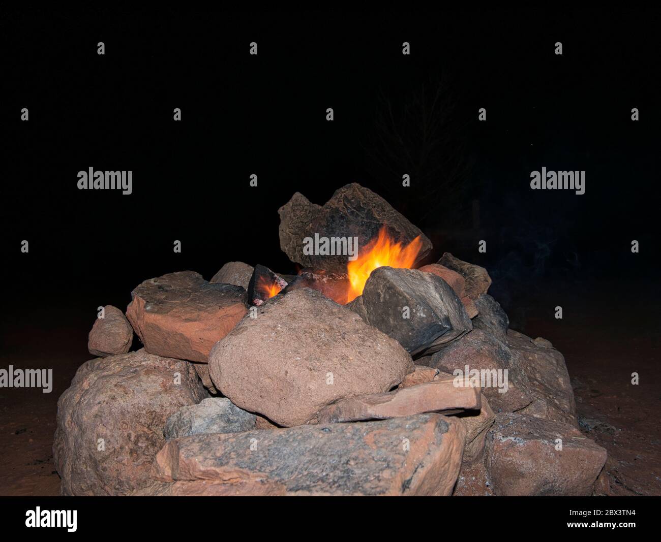 A small campfire in a fireplace of stones Stock Photo - Alamy