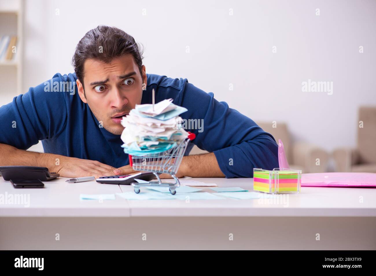 Young man in the budget planning concept Stock Photo - Alamy