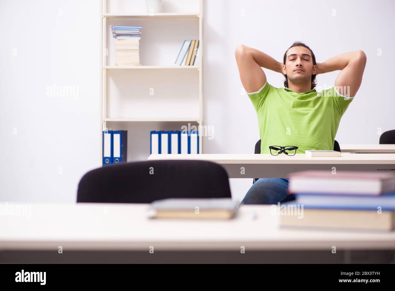 Young male student in the classroom studying Stock Photo - Alamy