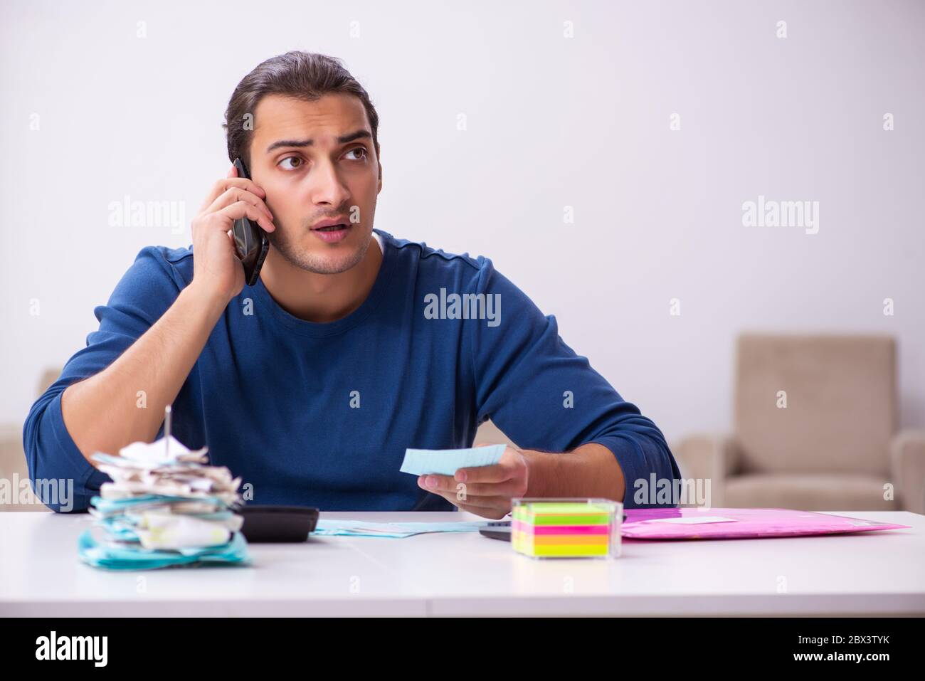 Young man in the budget planning concept Stock Photo - Alamy