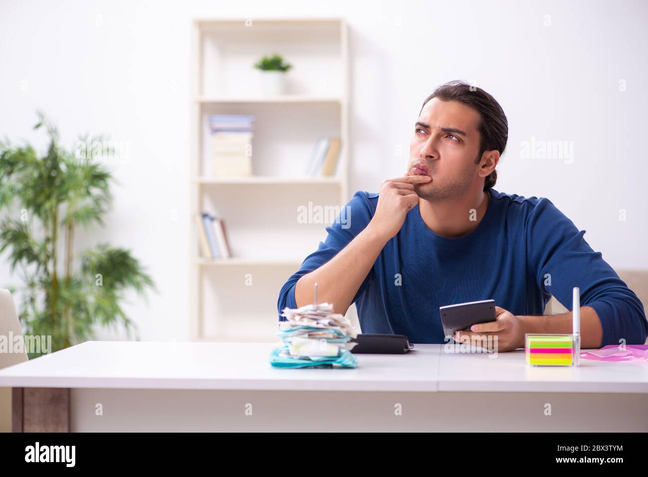Young man in the budget planning concept Stock Photo - Alamy