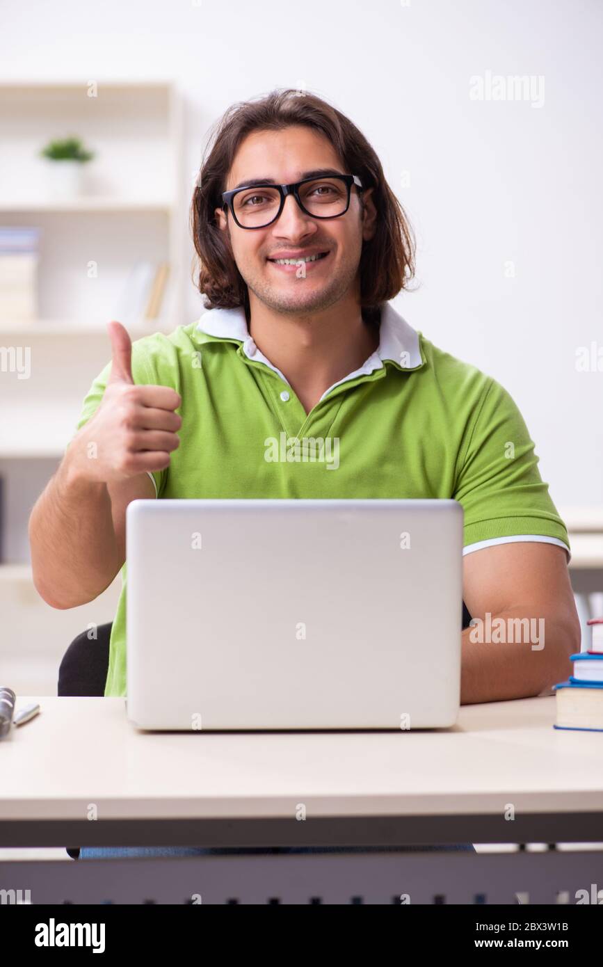 Young male student in the classroom studying Stock Photo - Alamy