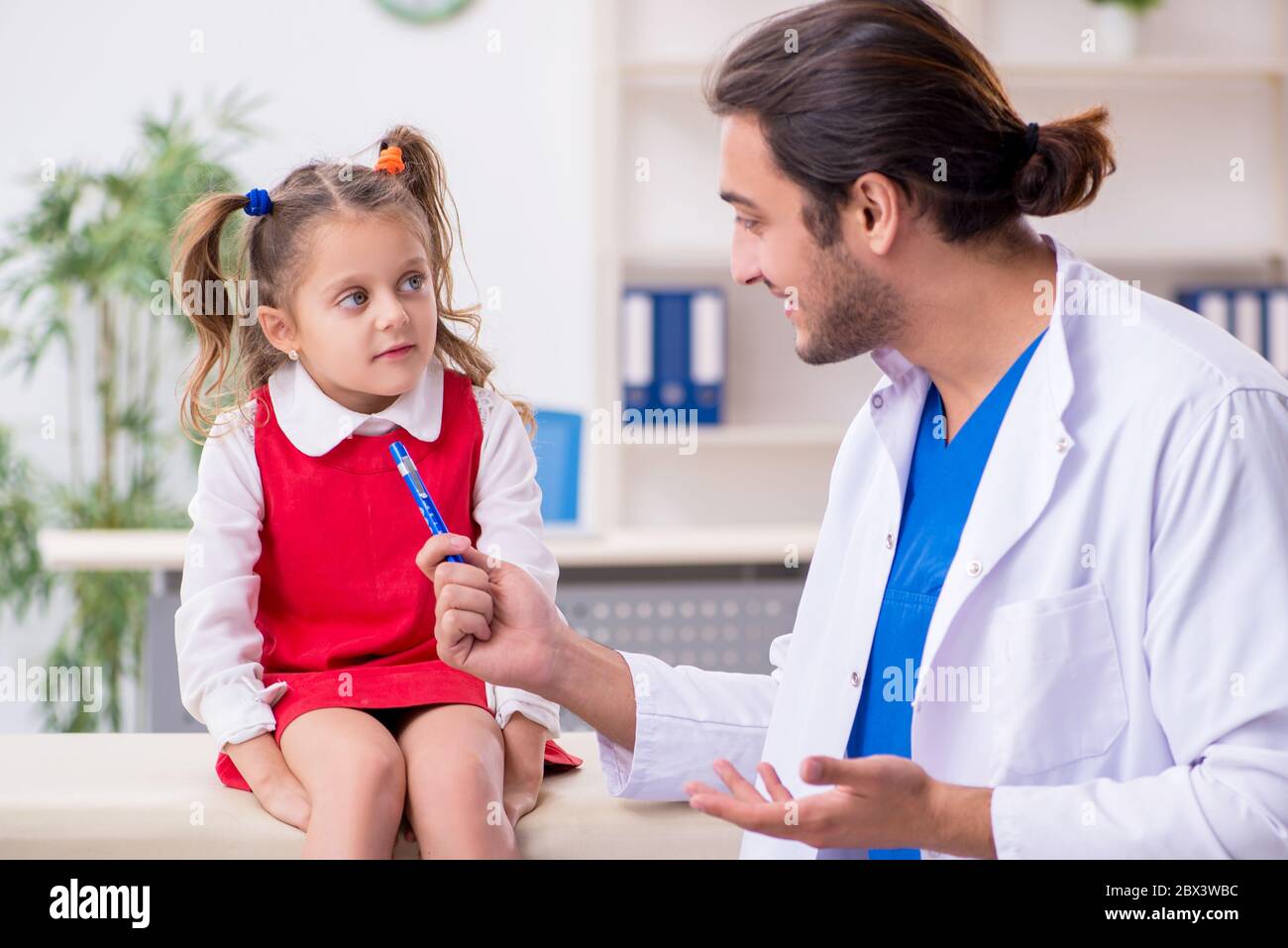 Small girl visiting young doctor oculist Stock Photo - Alamy