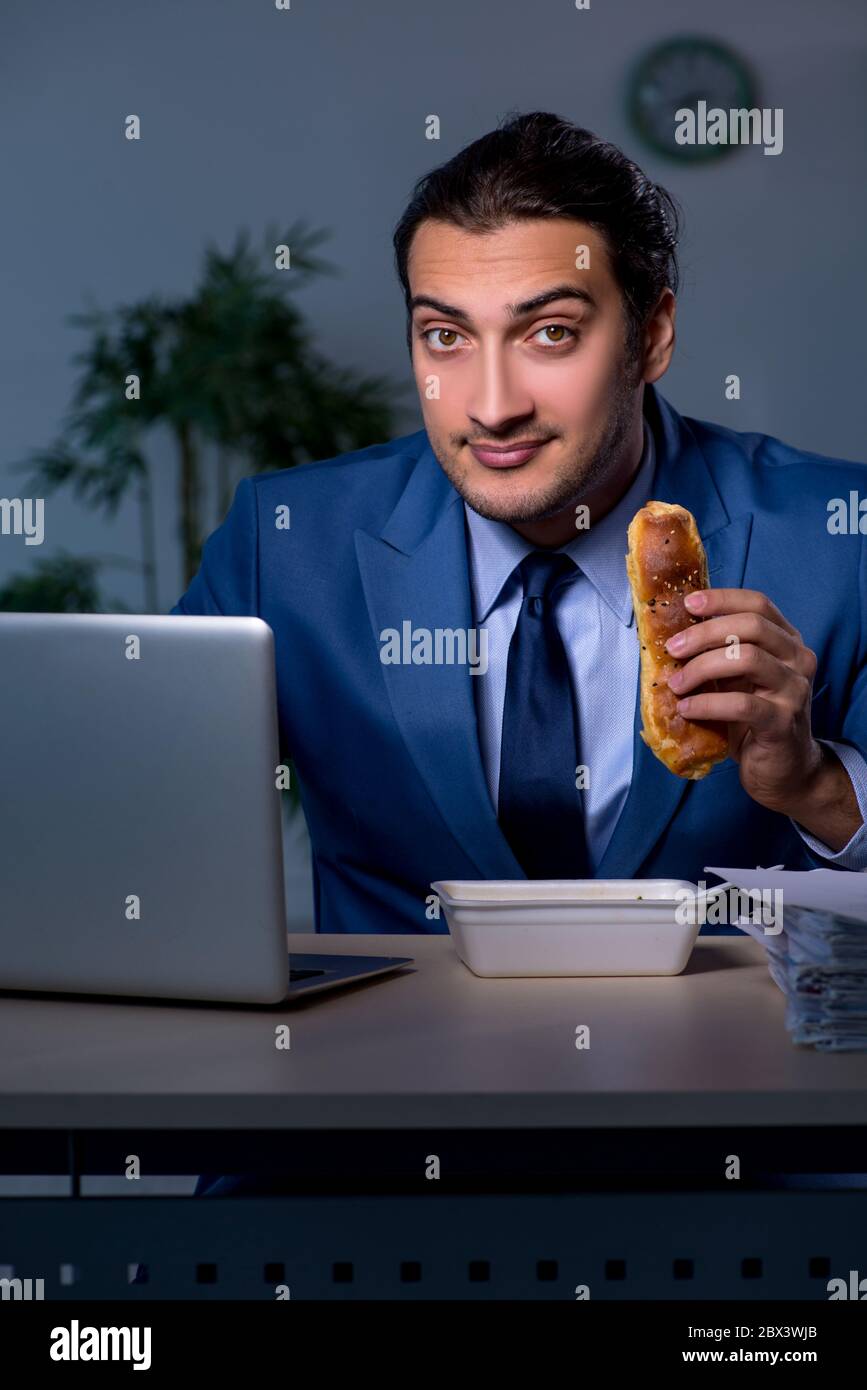 Hungry employee working late in office Stock Photo - Alamy