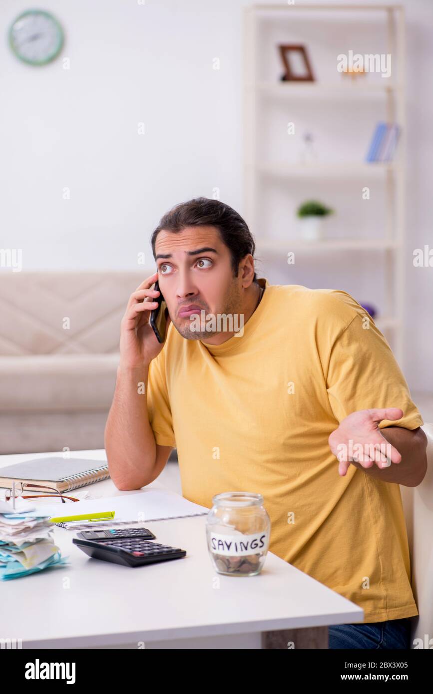 Young man in the budget planning concept Stock Photo - Alamy
