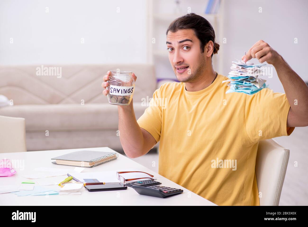 Young man in the budget planning concept Stock Photo - Alamy