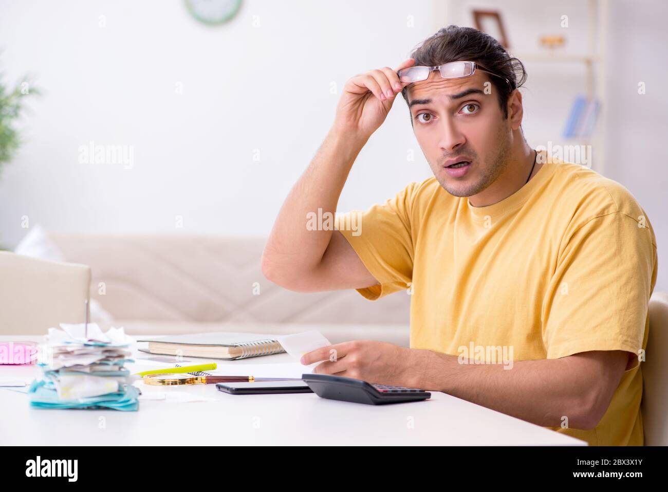 Young man in the budget planning concept Stock Photo - Alamy
