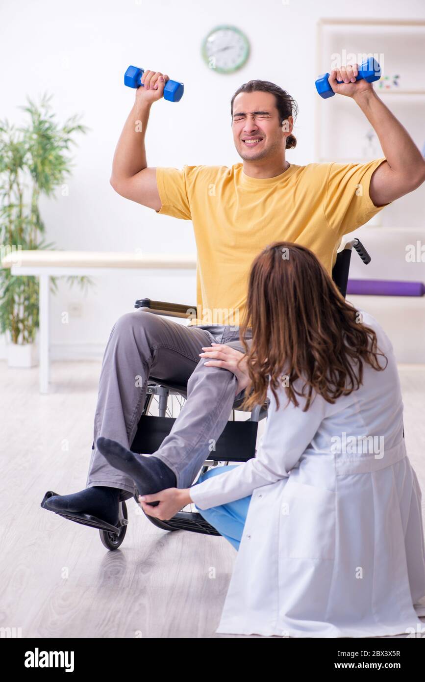 Young male patient in wheel-chair doing physical exercises in hospital ...