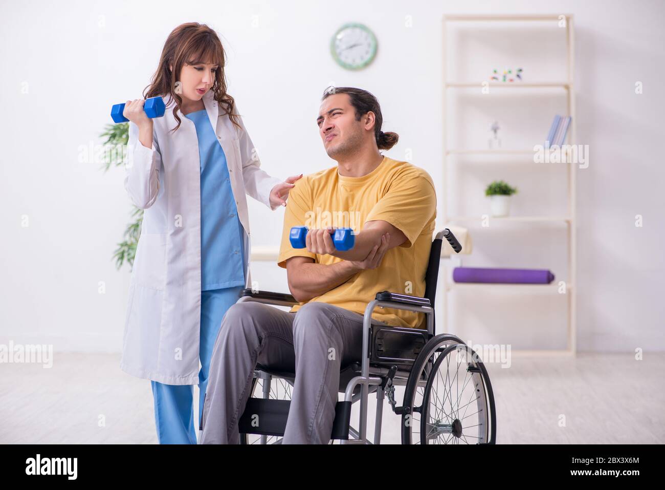 Young male patient in wheel-chair doing physical exercises in hospital ...