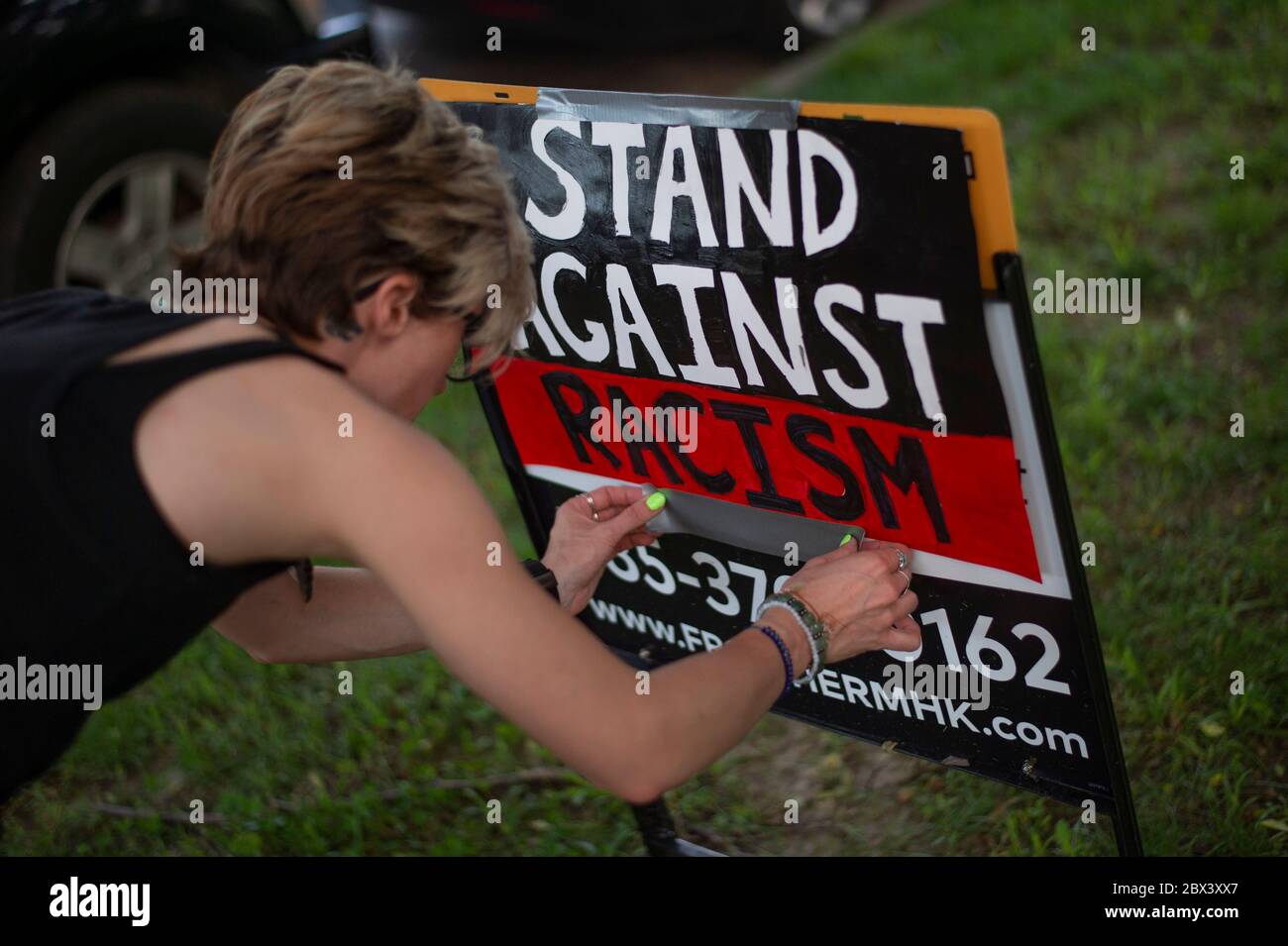 Manhattan, Kansas, USA. 3rd June, 2020. HANNAH FUNK, tapes a sign in ...