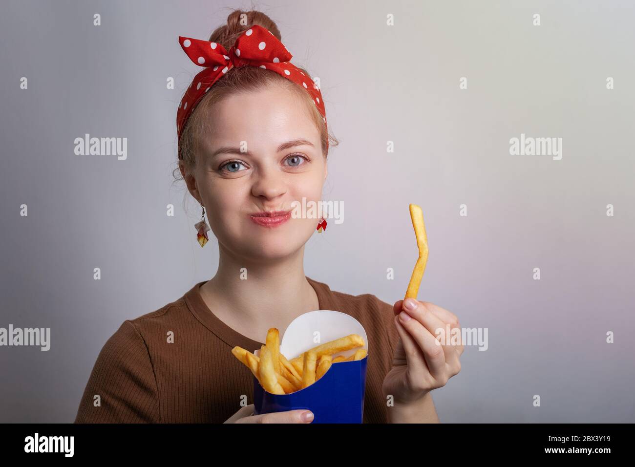 Happy young woman eating fries hi-res stock photography and images - Alamy