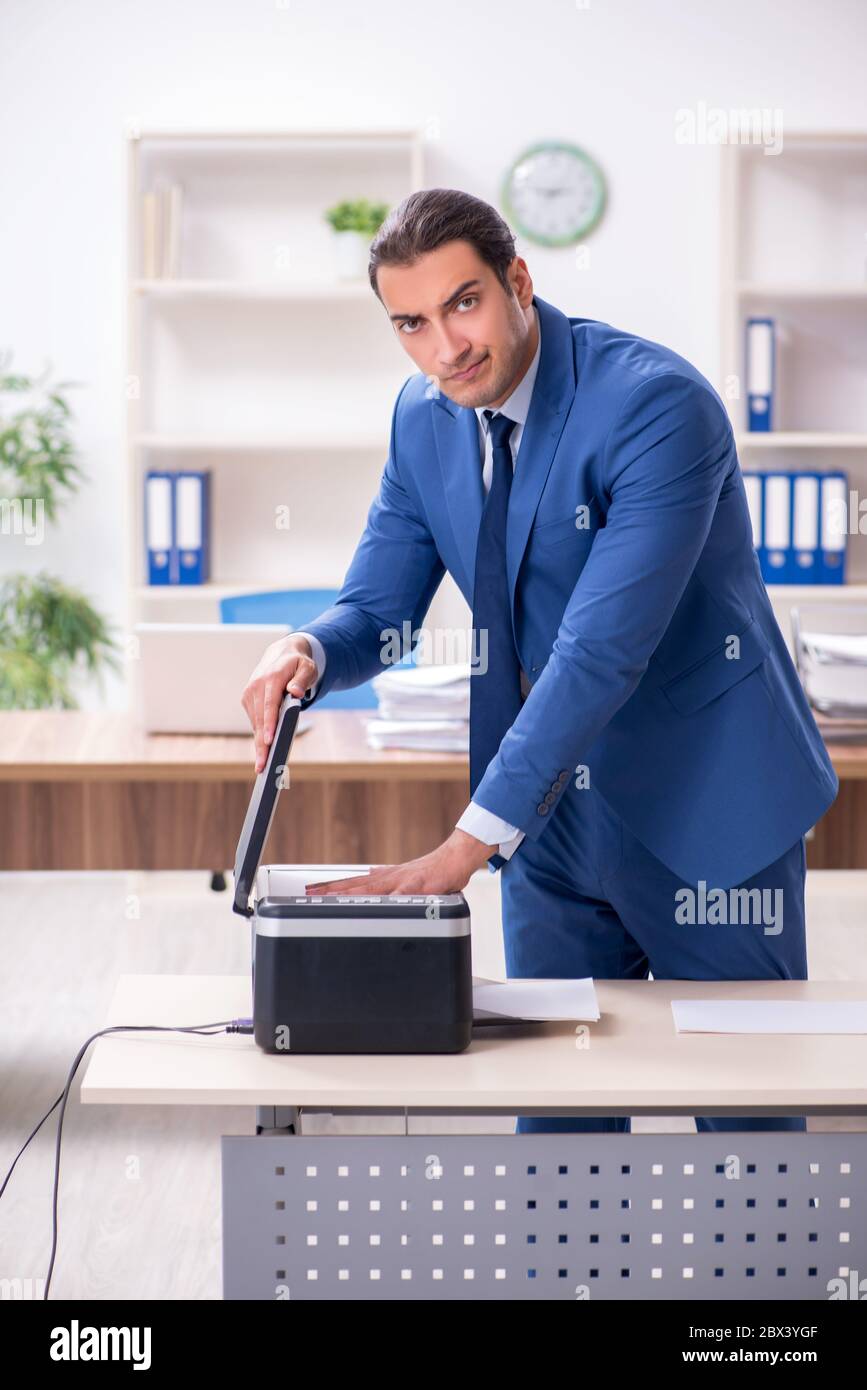 Young employee making copies at copying machine Stock Photo - Alamy