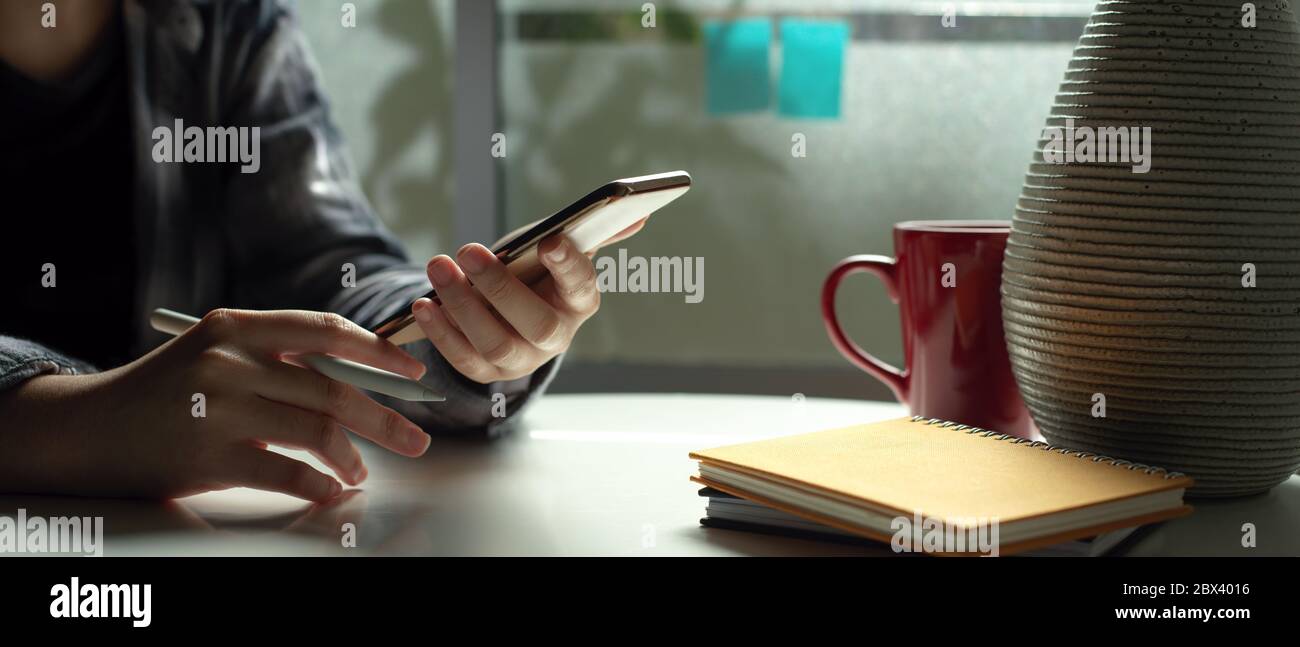 Side view of female freelancer using smartphone while sitting at coffee ...