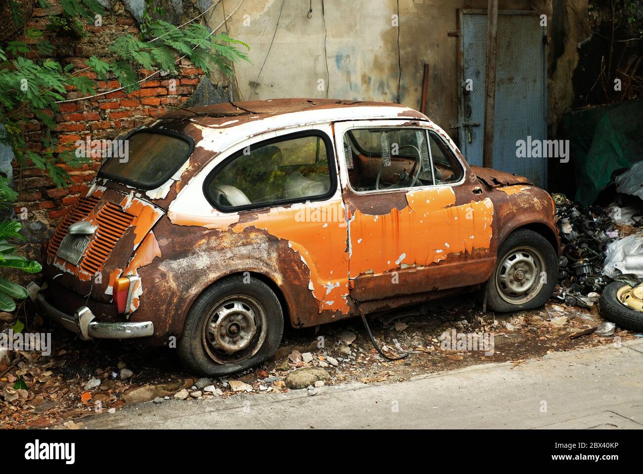 The old decay car left at wall Stock Photo - Alamy