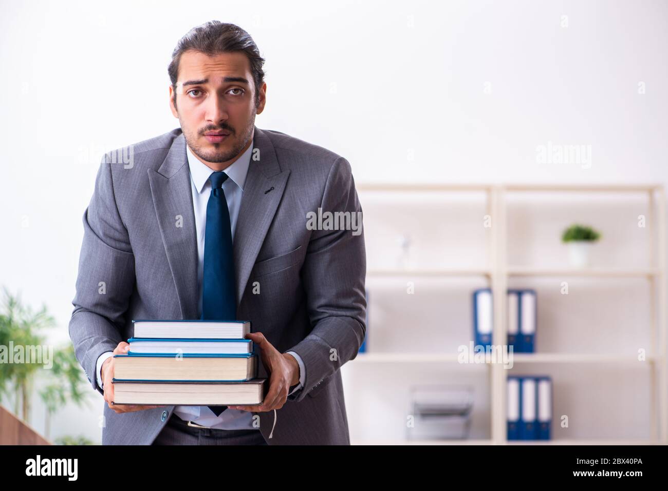 Young businessman reading books at workplace Stock Photo - Alamy