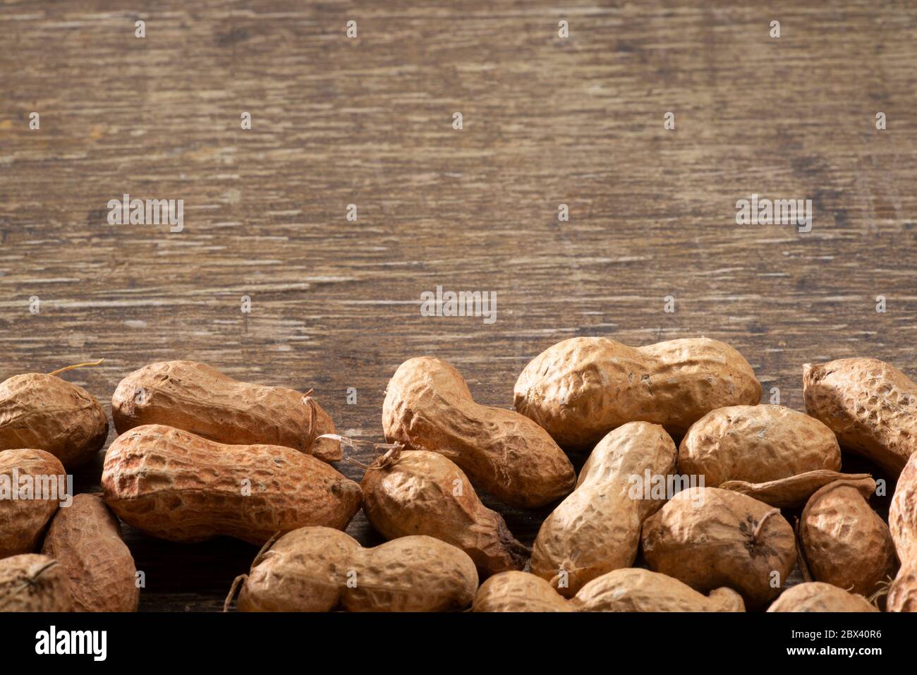 A row of peanuts in the shell making border on a brown background, Top ...
