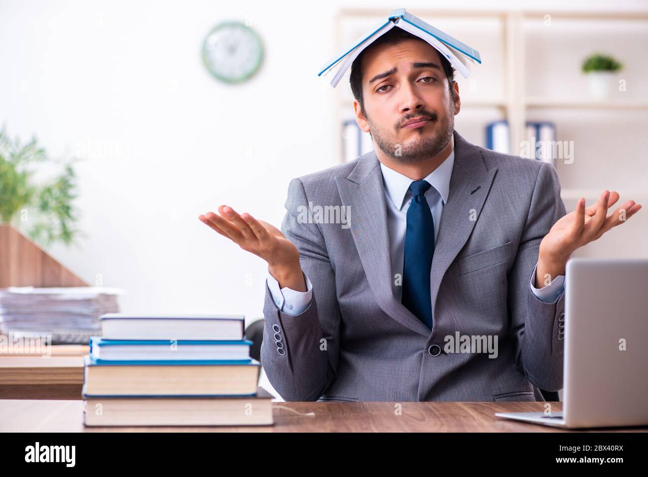 Young businessman reading books at workplace Stock Photo - Alamy