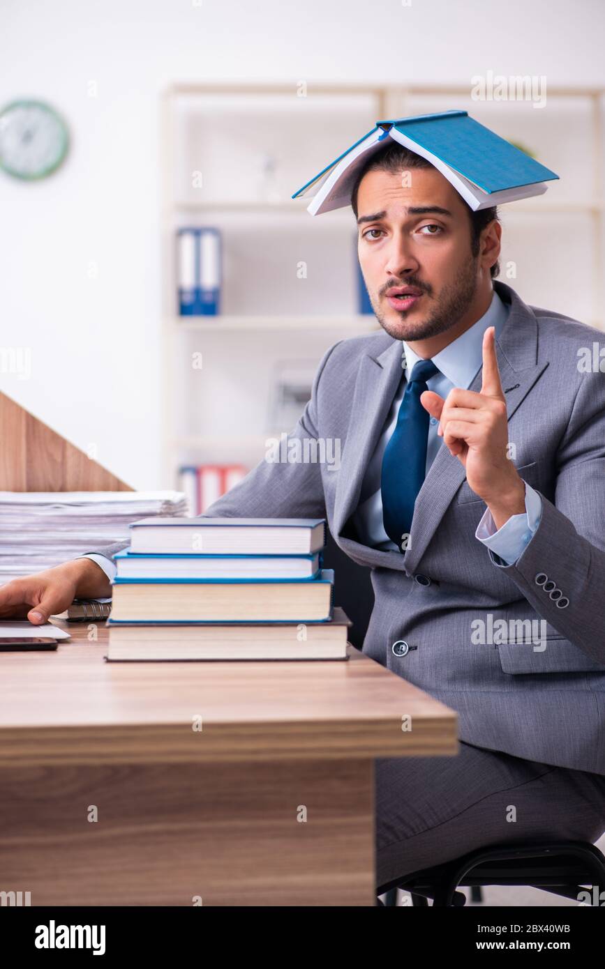 Young businessman reading books at workplace Stock Photo - Alamy