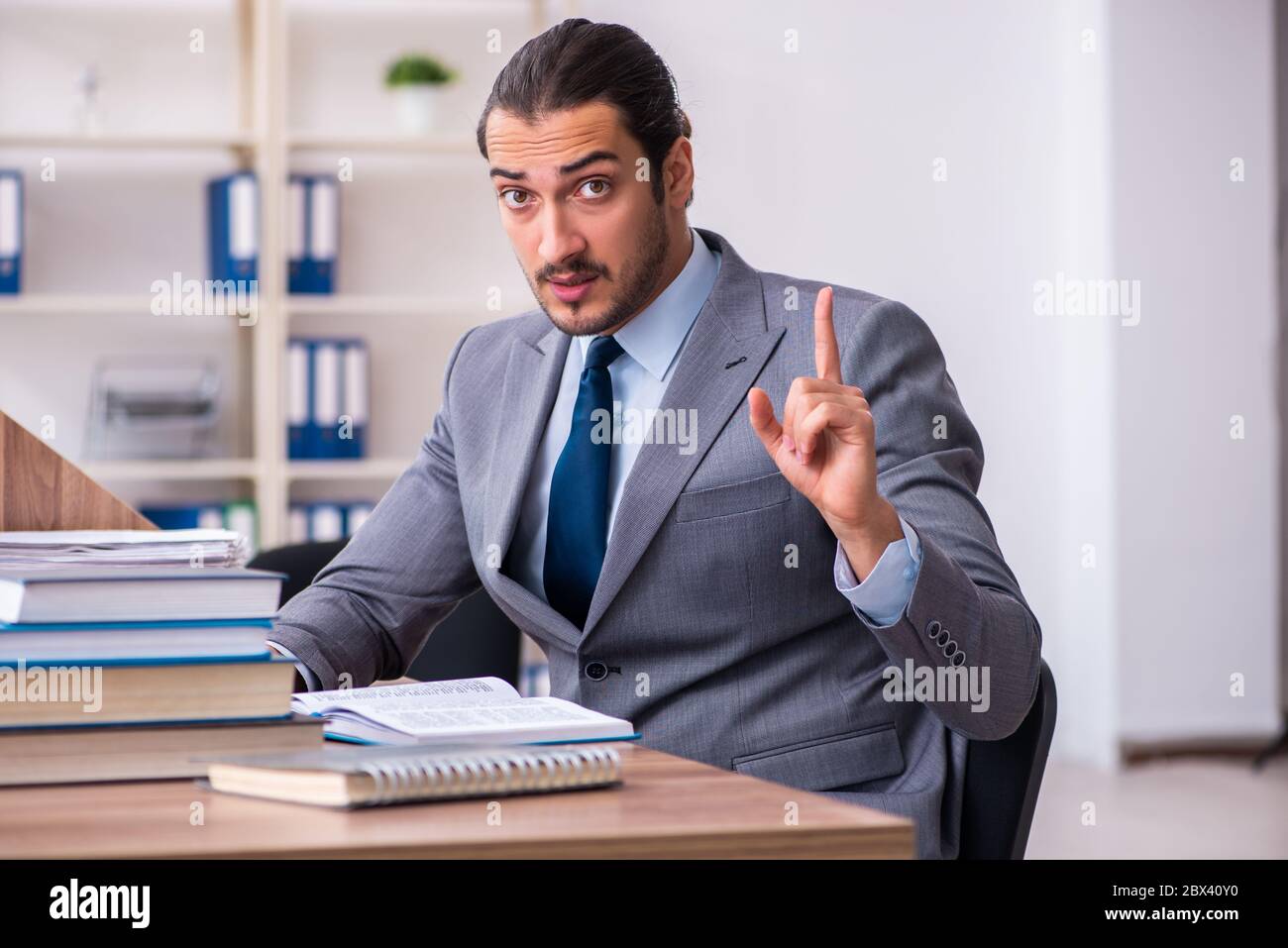 Young businessman reading books at workplace Stock Photo - Alamy