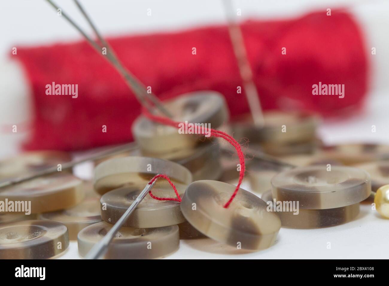Needle with thread and button isolated on white , needlework and ...