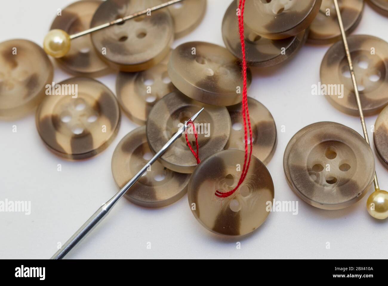 Needle with thread and button isolated on white , needlework and ...