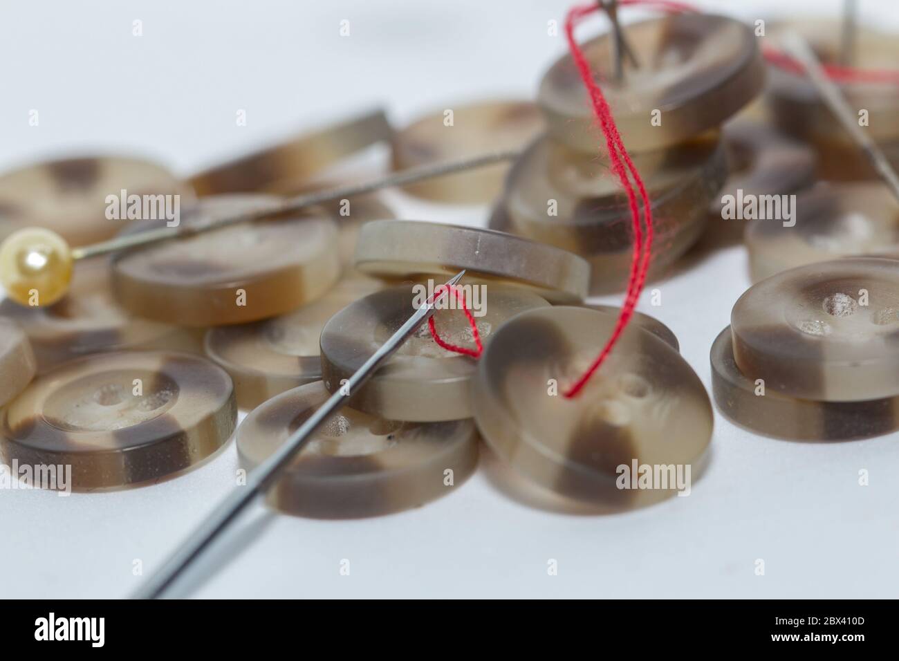 Needle with thread and button isolated on white , needlework and ...