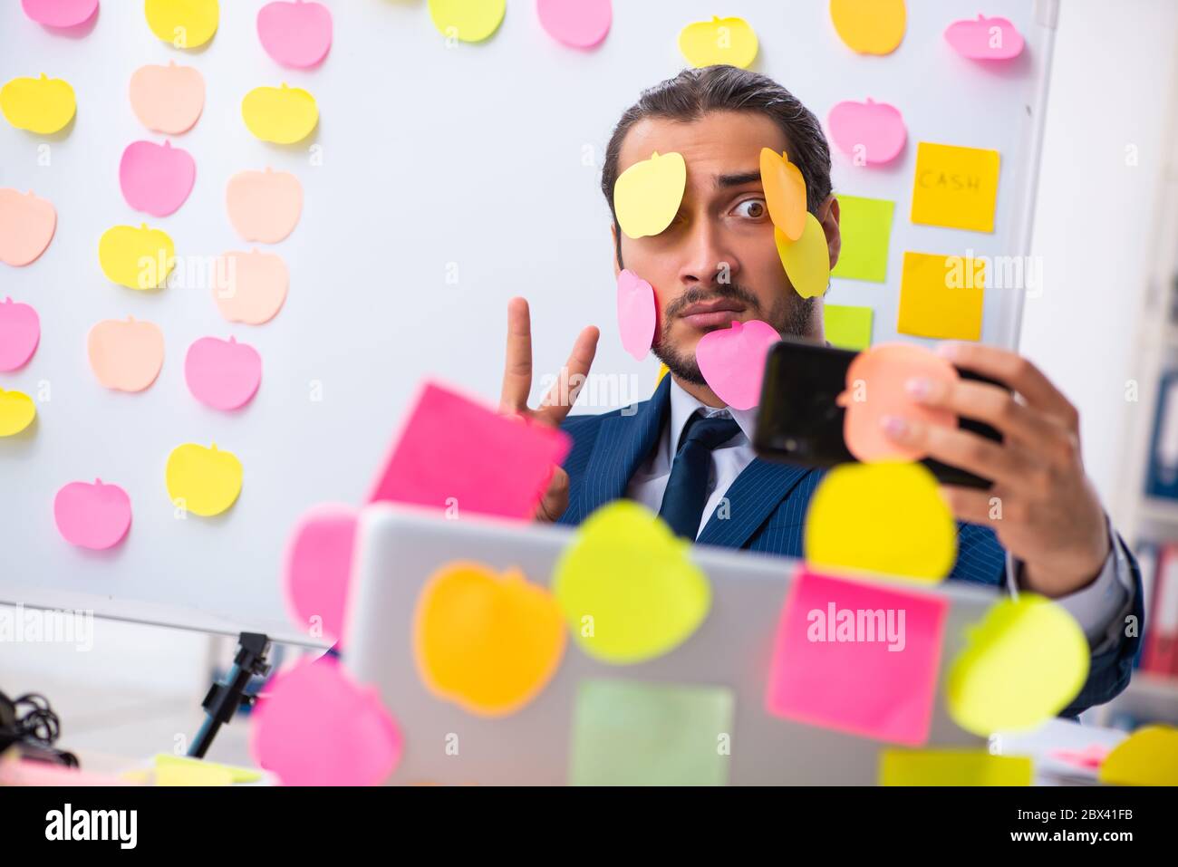 Young employee in conflicting priorities concept Stock Photo - Alamy