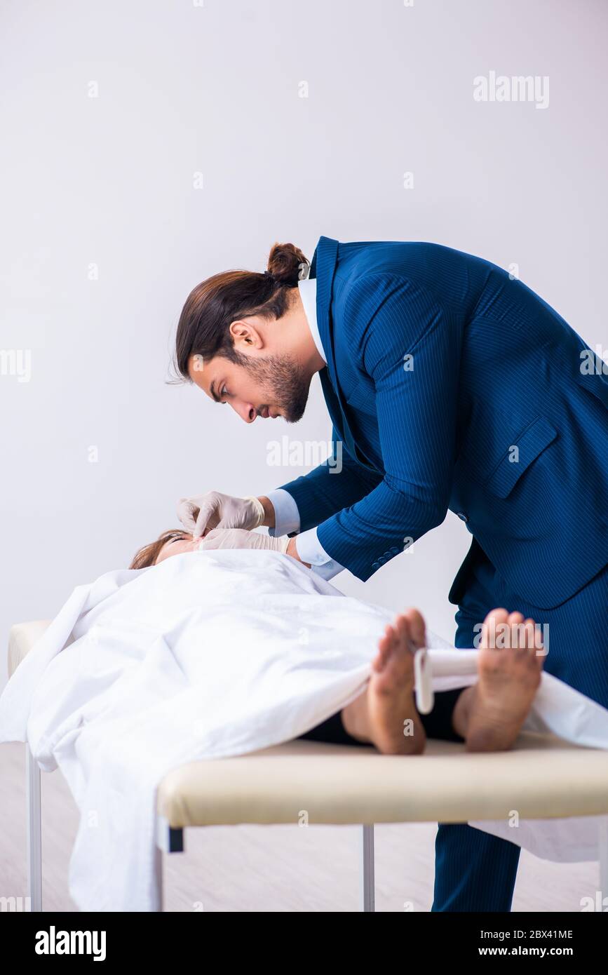 Police coroner examining dead body in morgue Stock Photo - Alamy