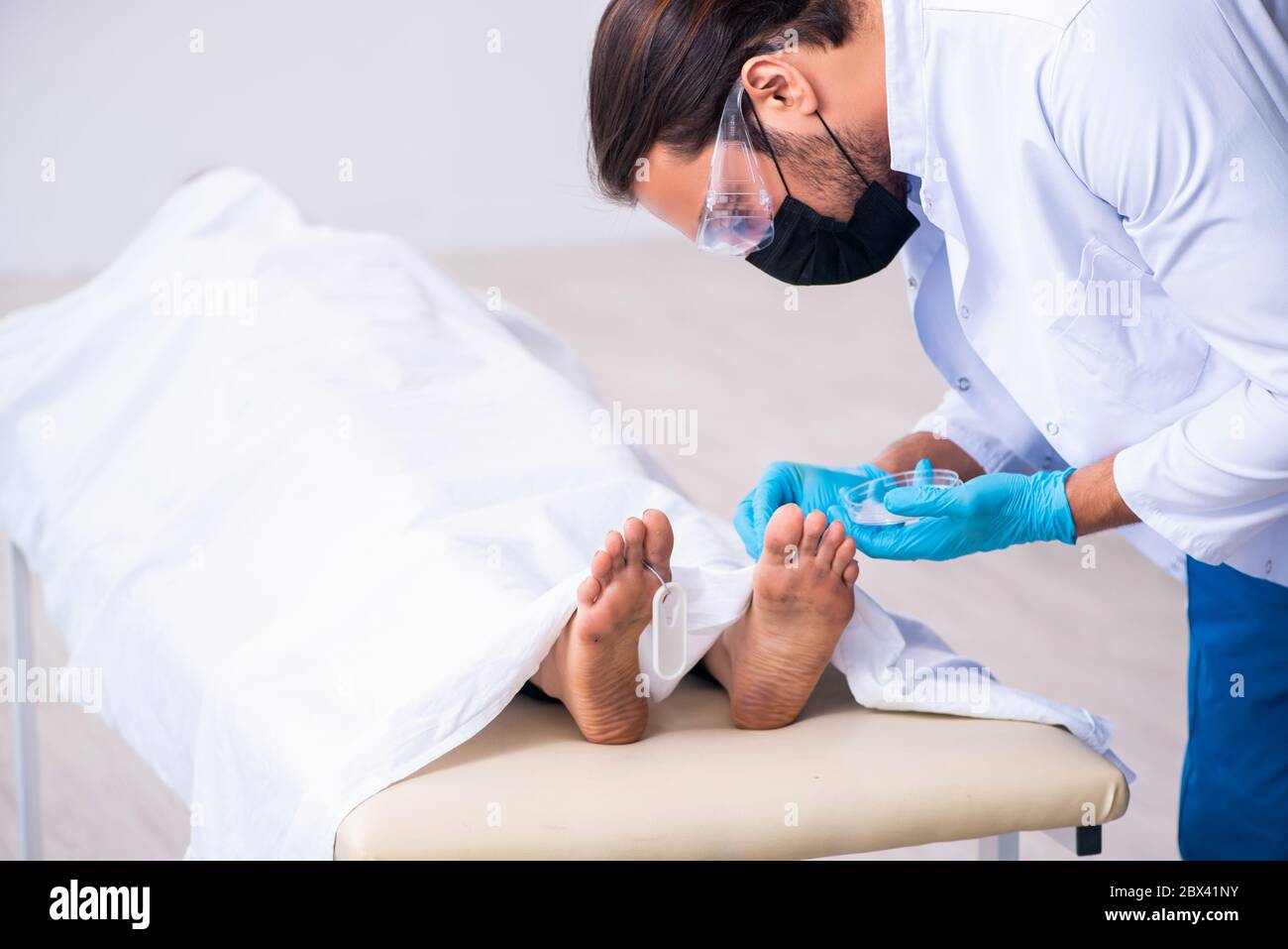 Police coroner examining dead body in morgue Stock Photo - Alamy