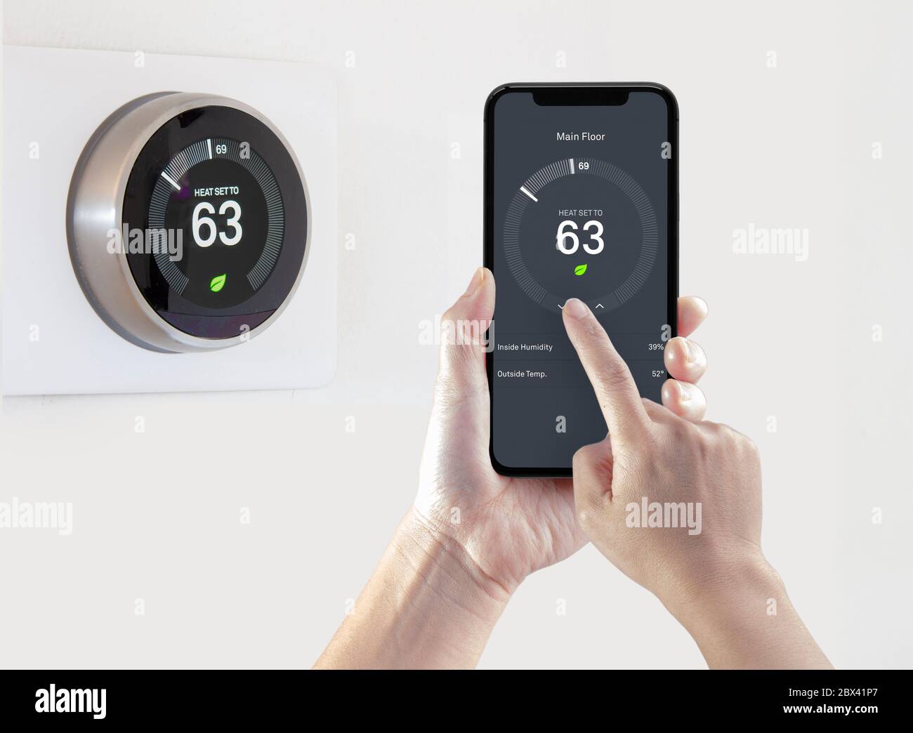 A person using a smart phone application saving energy with a wireless ...