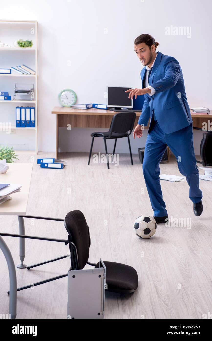 Young employee playing football in the office Stock Photo - Alamy