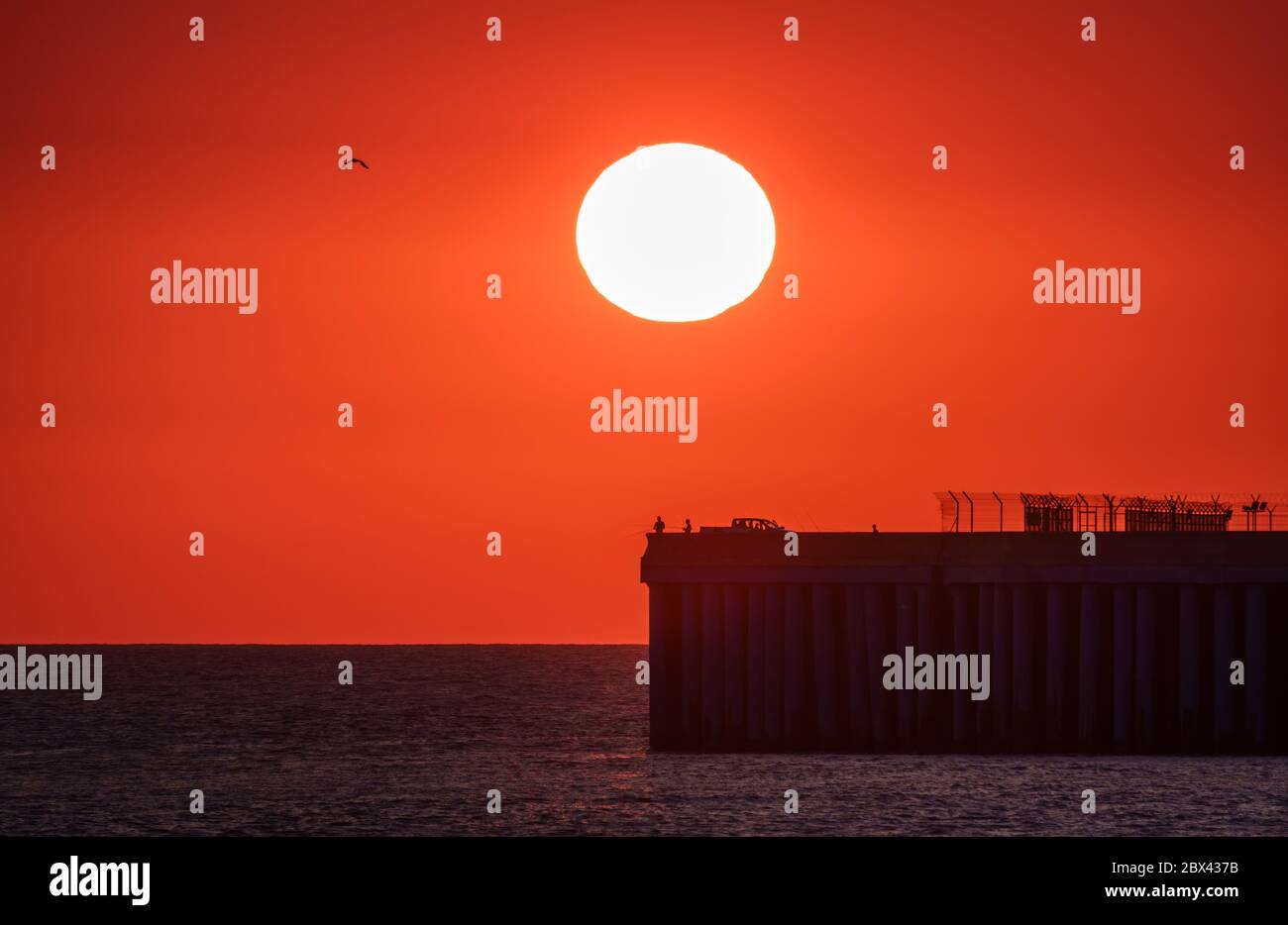 Beautiful red and orange sunset over the sea in a cloudy sky. The sun ...