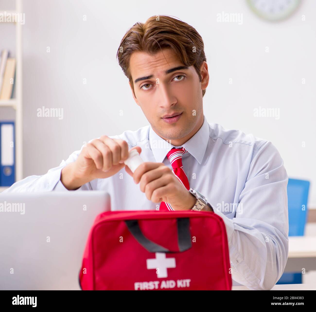 The man with first aid kit in the office Stock Photo - Alamy