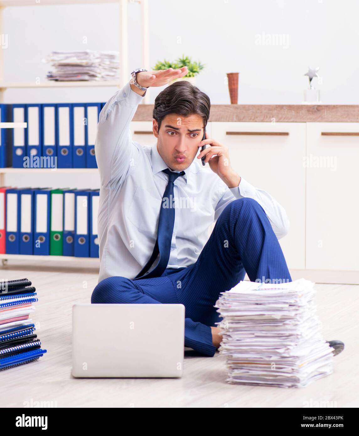 The extremely busy employee working in the office Stock Photo - Alamy