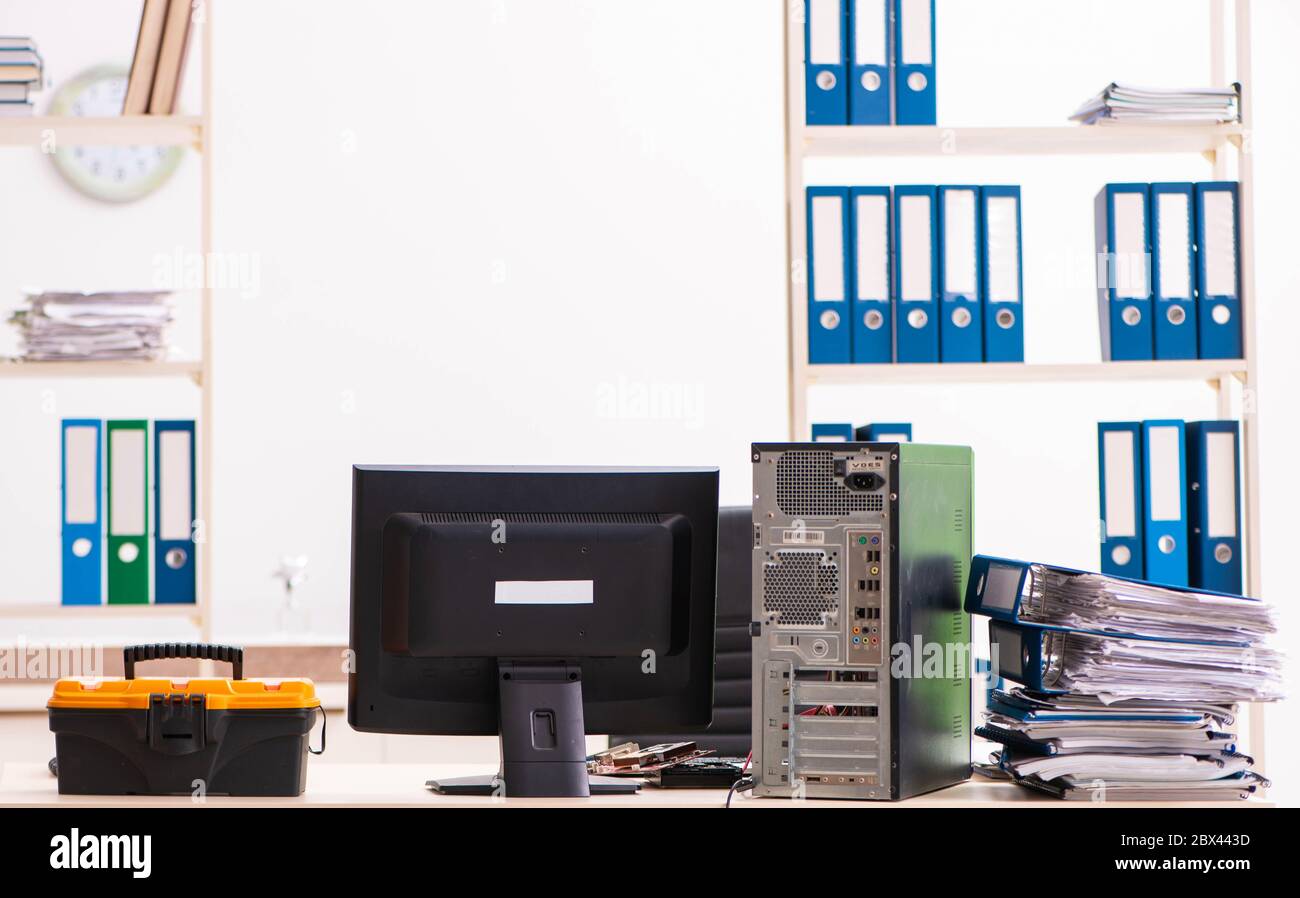 The young engineer repairing broken computer at the office Stock Photo ...