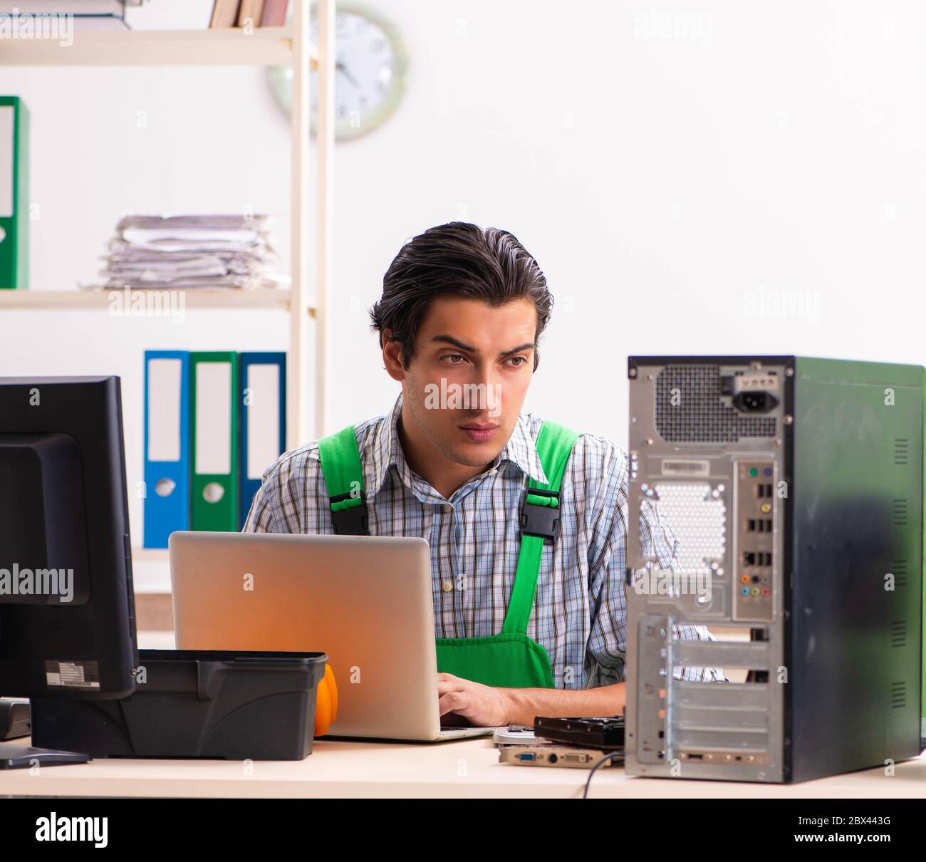 The young engineer repairing broken computer at the office Stock Photo ...