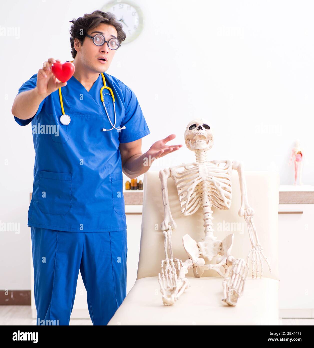 The funny doctor with skeleton in hospital Stock Photo - Alamy