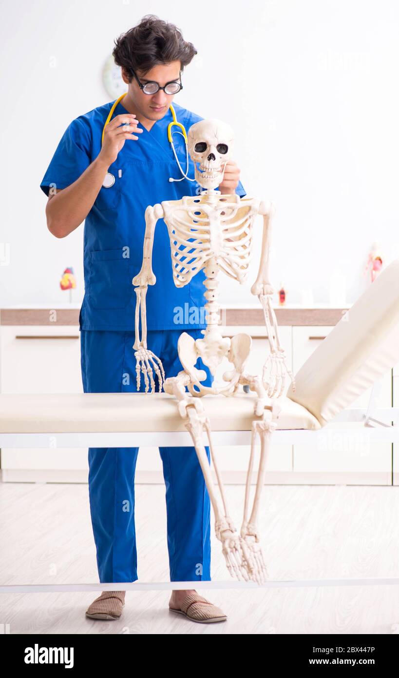 The funny doctor with skeleton in hospital Stock Photo - Alamy