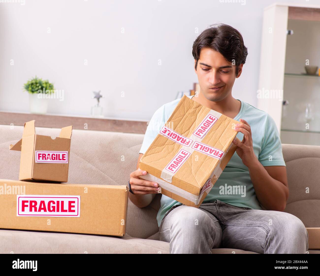 The man opening fragile parcel ordered from internet Stock Photo - Alamy