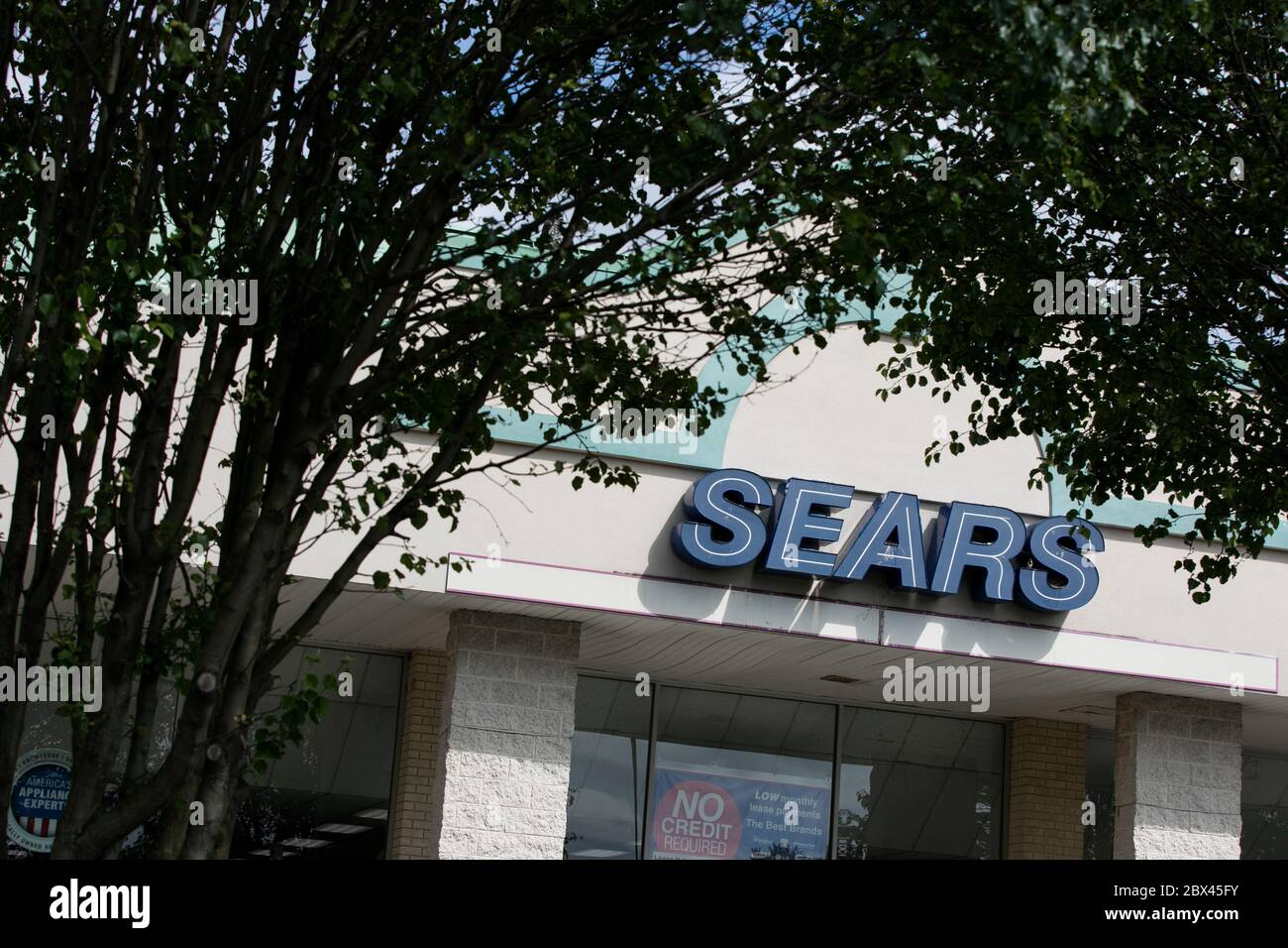 A logo sign outside of a Sears Hometown retail store location in ...