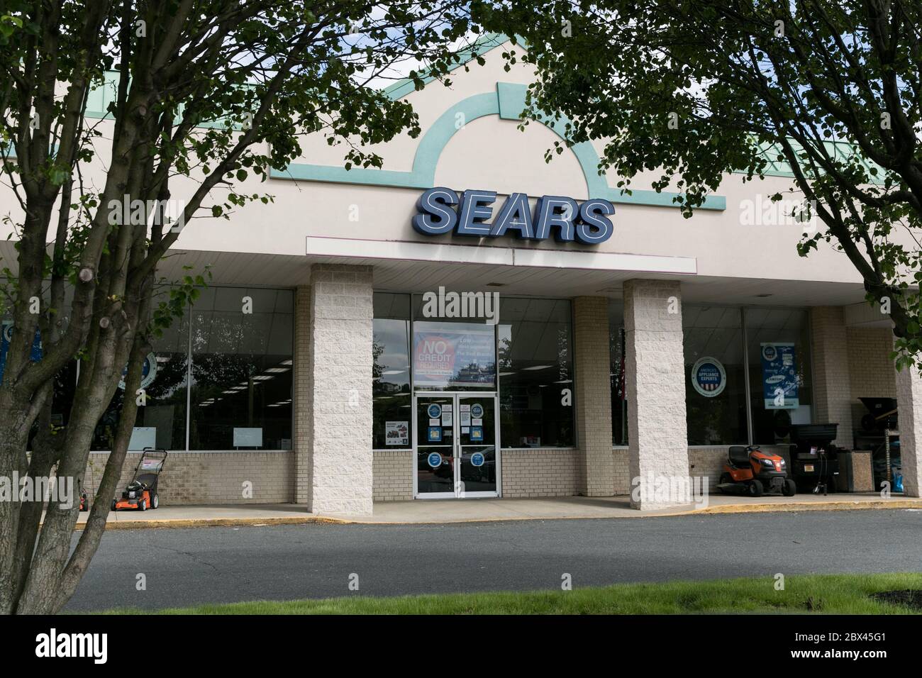 A logo sign outside of a Sears Hometown retail store location in ...