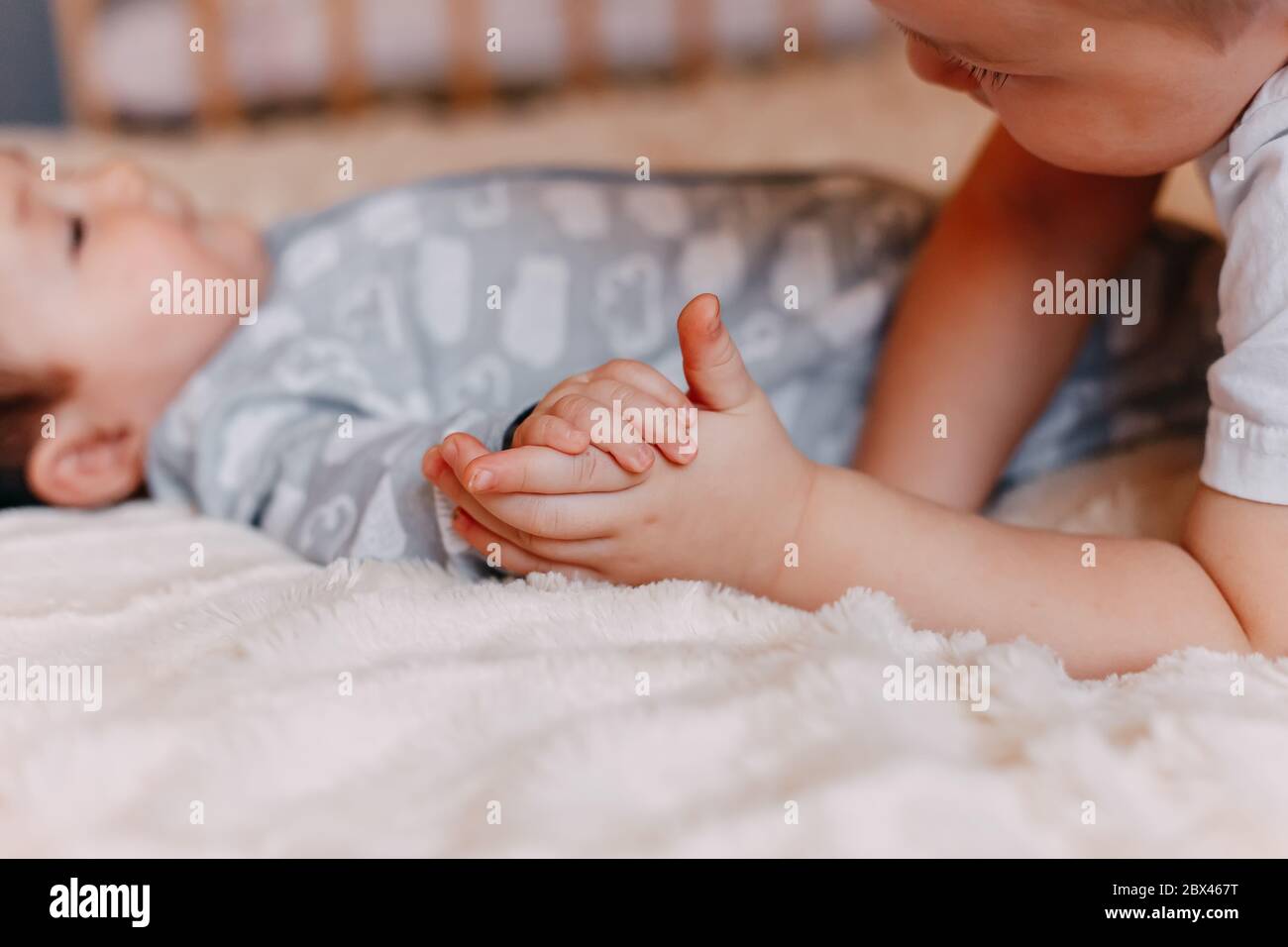 brother holding for the newborn baby hand by hand Stock Photo - Alamy