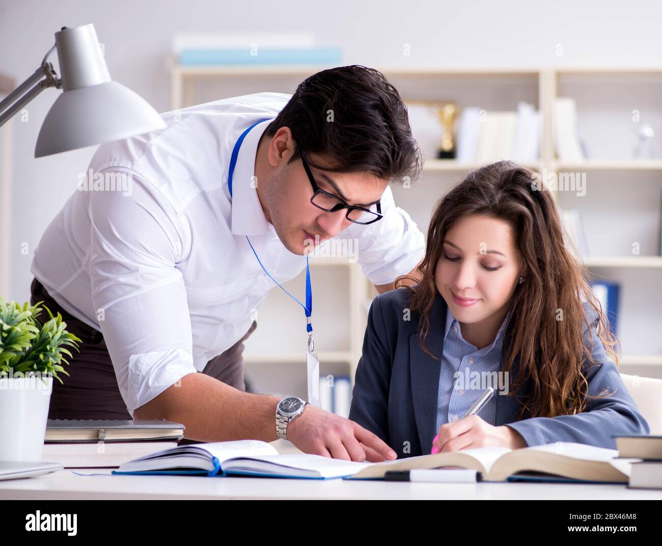 The teacher explaining to student at lecture Stock Photo - Alamy