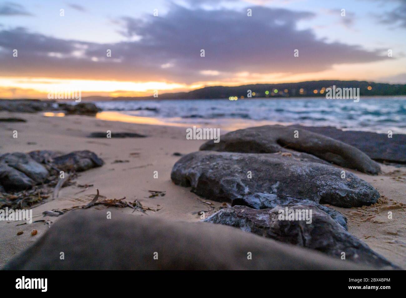 Beach Sunset with Rocks in forefront Stock Photo - Alamy