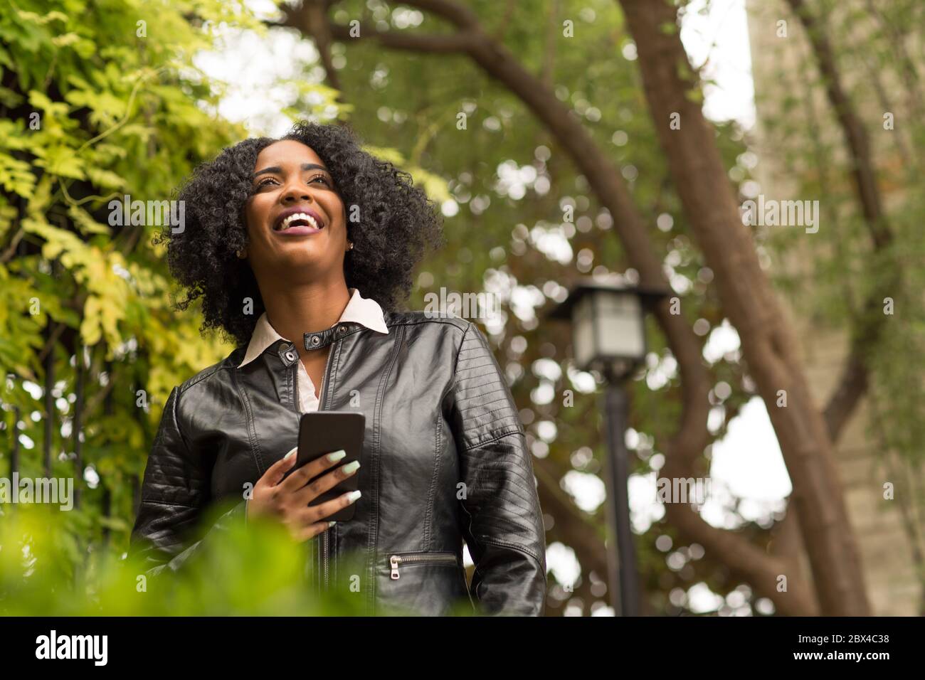 Confident African American Woman walking and texting Stock Photo - Alamy