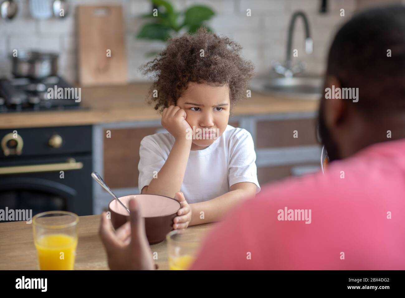 Cute little kid looking sad not wanting to eat Stock Photo - Alamy